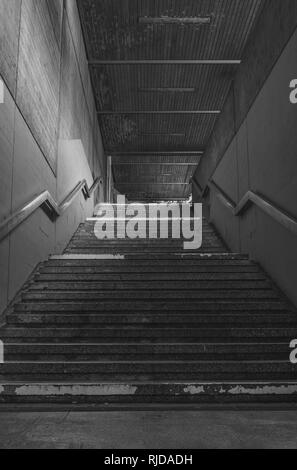 Upstairs in a underground passage with concrete walls and metal ...