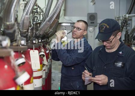 An armed crew member aboard the amphibious transport dock USS RALEIGH ...