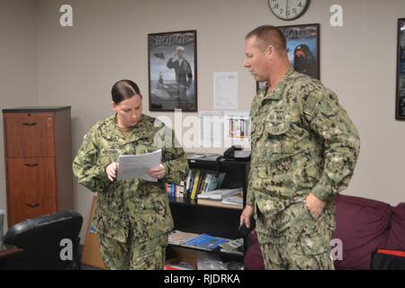 Danielle Weisner helps Chief Warrant Officer Chad Ruff with paperwork ...