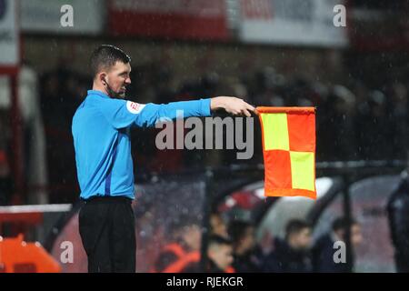 Soccer / football referee assistant, linesman points flag to indicate ...