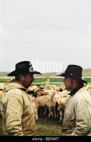 Cowboys talking during a spring branding Stock Photo - Alamy