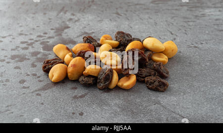 Side view of a small portion of peanuts and raisins isolated on a white ...