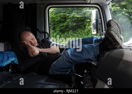 Motorist is sleeping in the cab of his truck Stock Photo - Alamy