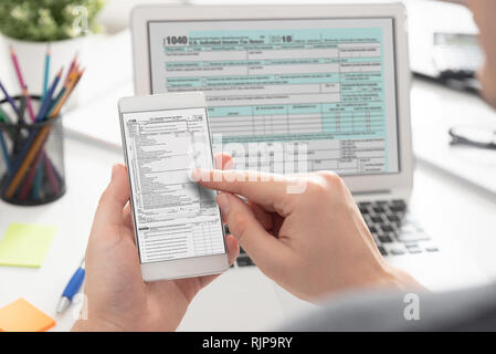 Man using smartphone for online tax filing and mobile financial ...
