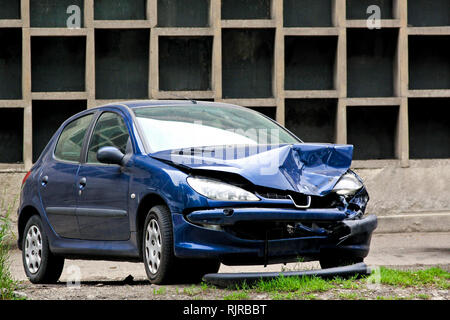Car accident. Blue small car crashed into a street lamp post on a sunny ...
