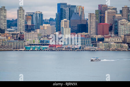 A boat cruises across Elliott Bay in front of the Seattle skyline Stock ...