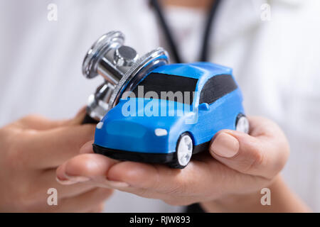 Female hand holding miniature toy Christmas tree through a hole in red ...