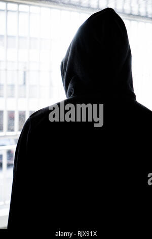 Rear view silhouette of a hooded male at the door Stock Photo - Alamy