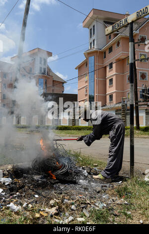 KENYA, Nairobi, city centre, waste picker burns garbage and cable ...