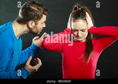 Husband abusing wife. Aggresive man screaming at crying scared woman ...