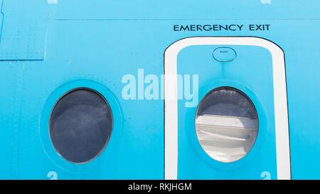 Windows of airplane with emergency exit door Stock Photo - Alamy