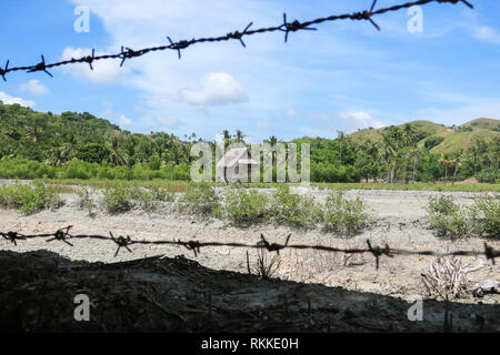 Rustic fence on a farm with barbed wire strands on metal droppers ...