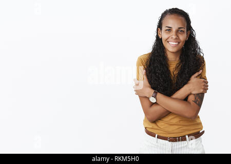 Portrait of optimistic cute curly girl hands chest wear white t-shirt ...