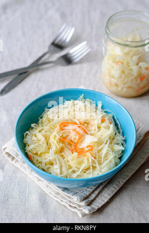 sauerkraut, marinated cabbage on a blue ceramic plate on a gray wooden ...