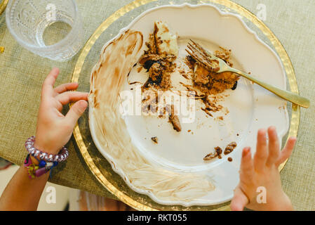 Elegant dish soiled and finished with child's hands finishing eating ...