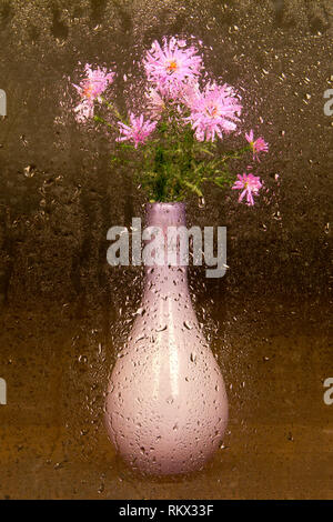 Vase with lilac flowers and cloth on table in room Stock Photo - Alamy