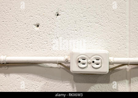 Isolated North American power outlet plug in socket on a white wall ...