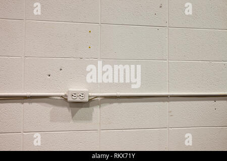 Isolated North American power outlet plug in socket on a white wall ...