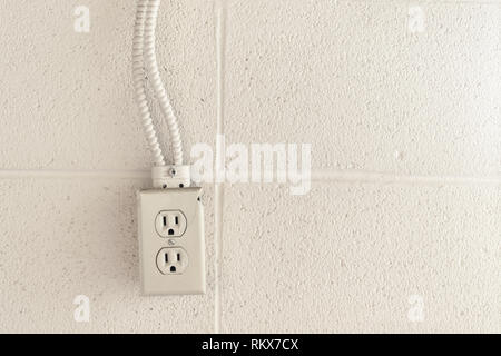 Isolated North American power outlet plug in socket on a white wall ...