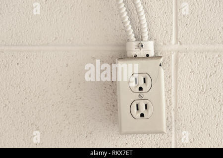 Isolated North American power outlet plug in socket on a white wall ...