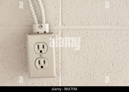 Isolated North American power outlet plug in socket on a white wall ...