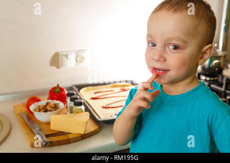 Small boy making pizza with ingredients on the kitchen Stock Photo - Alamy