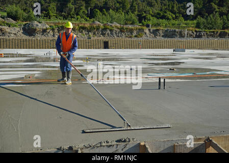 A builder floating off new concrete for a large building Stock Photo ...