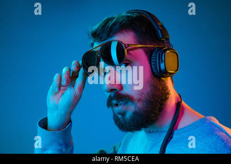 Enjoying his favorite music. Serious young stylish man in sunglasses ...