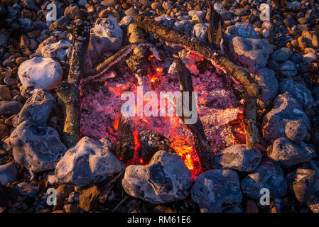 Small fire on a pebble beach Stock Photo - Alamy