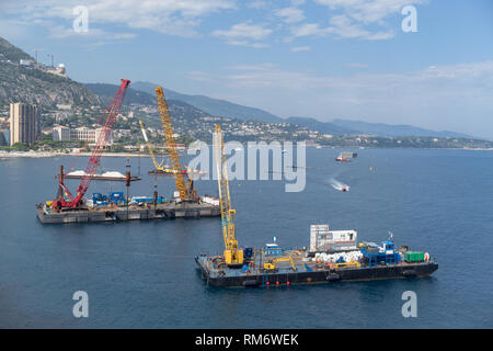 A construction crane barge begins land reclamation work off the coast ...