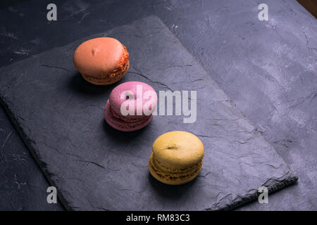 Photo in a dark key French sweet multi-colored macaroni Stock Photo - Alamy