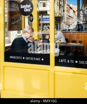 Spain, Father and daughter sitting on a rock at a mountain lake ...