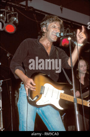 Musician John Cafferty is shown performing on stage during a "live ...