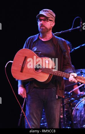 Cake vocalist and guitarist John McCrea is shown performing on stage ...