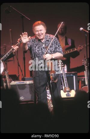 Musician Roy Clark is shown performing on stage during a "live" concert ...