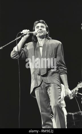 The Monkees are shown performing on stage during a "live" concert ...
