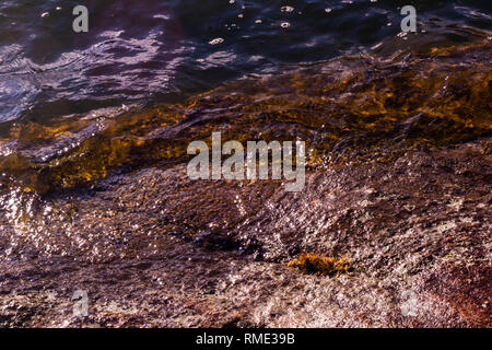 Water lapping onto a rocky lake-shore Stock Photo - Alamy