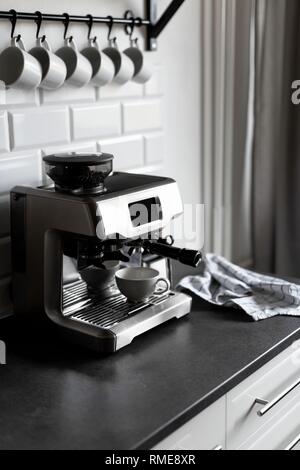 Cups of fresh coffee and a classic coffee maker on white table Stock ...