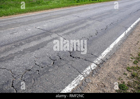 Bad asphalt road with white line Stock Photo - Alamy