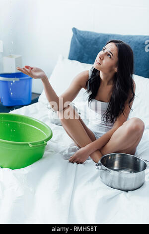 Leaky bucket with water on blue background Stock Photo - Alamy
