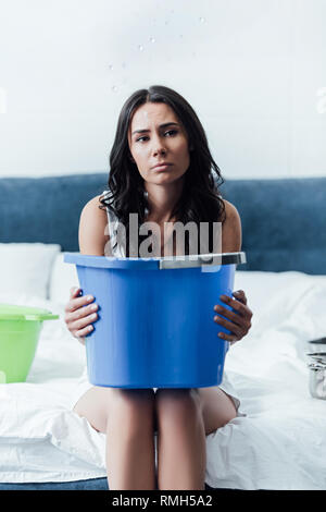 Woman holding leaky bucket with water against blue sky, closeup Stock ...