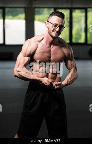 Portrait Of A Young Physically Fit Nerd Man Showing His Well Trained ...