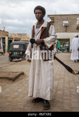 Beja tribe warrior with his sword in front of a pink wall, Red Sea ...