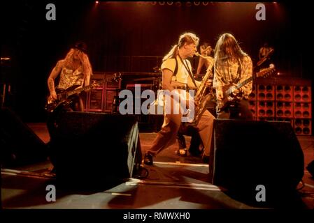 Extreme band members are shown on stage during a "live" concert ...