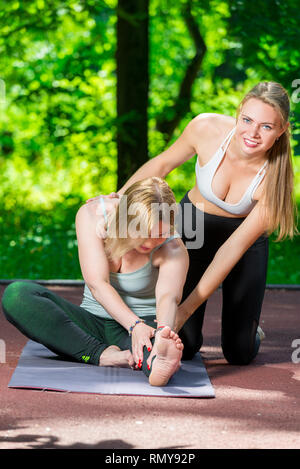 Female trainer helps a woman do stretching exercises Stock Photo - Alamy