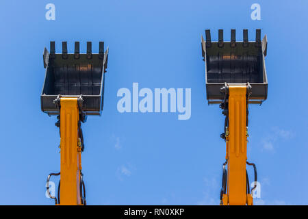 Two heavy, yellow and black excavators on construction site moving soil ...