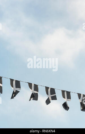 String of St. Piran's Cornwall / Cornish flags fluttering in the breeze ...