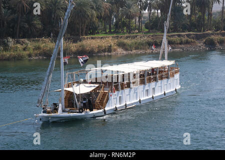 A dahabiya sailing on the river Nile Egypt, near the bank with palms ...