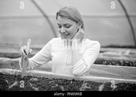 A young woman is digging a hole in a garden Stock Photo - Alamy
