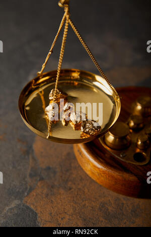 golden stones on scales on marble table and black background Stock ...